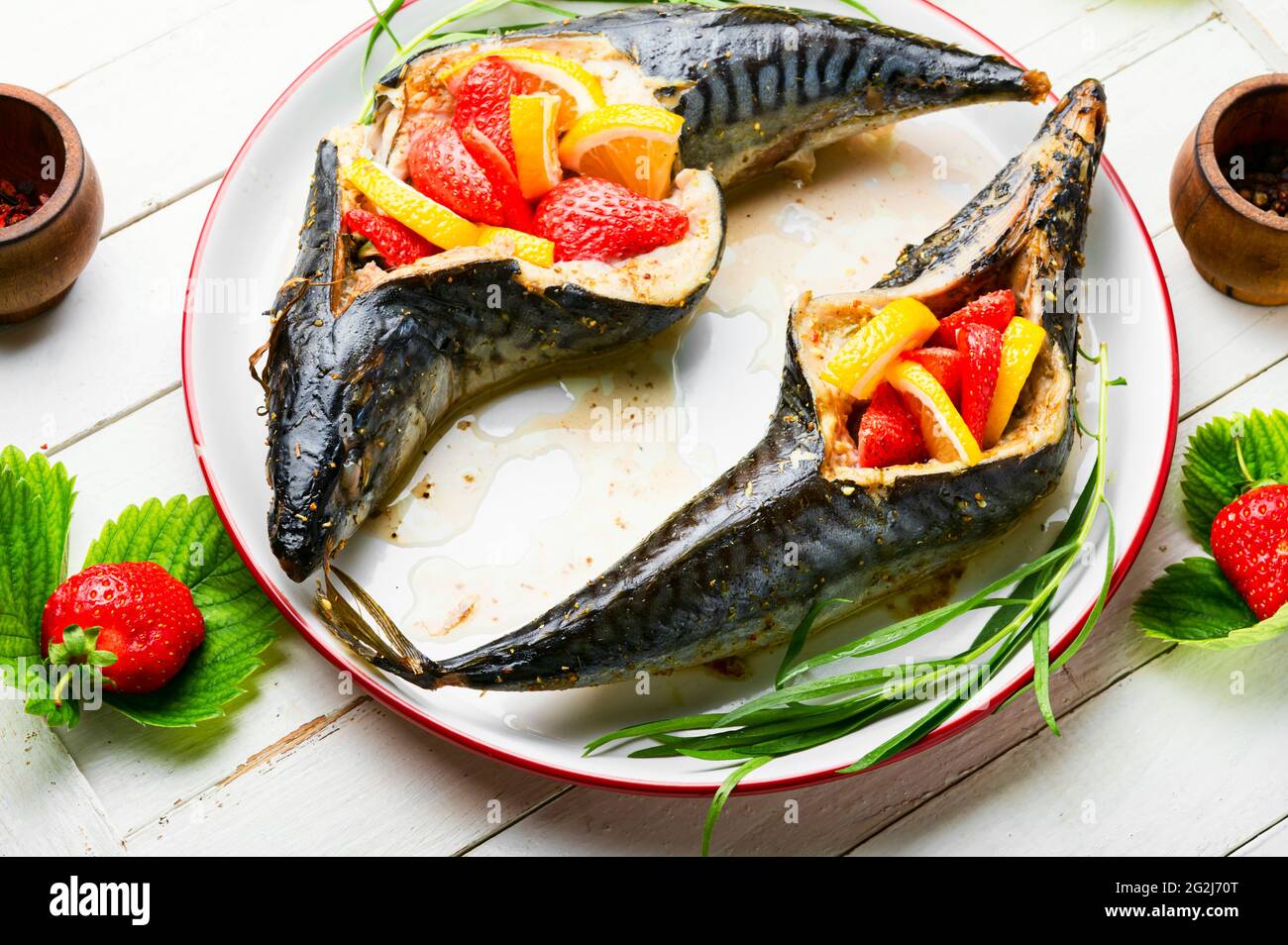 Fish baked with berries and lemon in the plate.Summer fish dish,baked ...