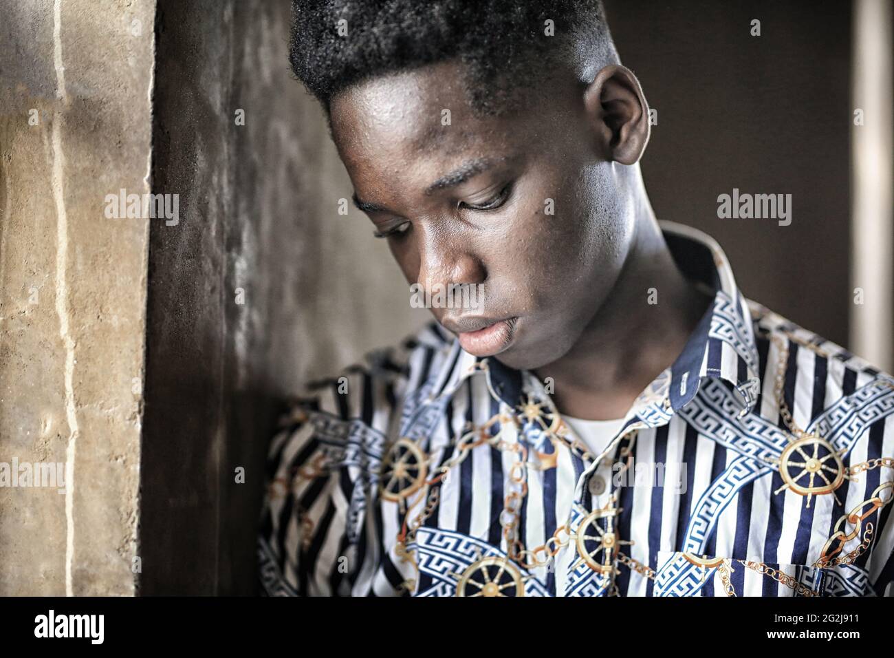 Portrait of young black skin man standing against wooden door Stock ...