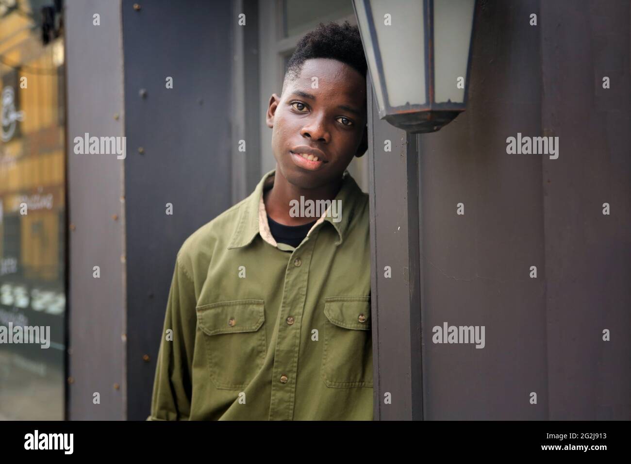 Portrait of young black skin man standing against wooden door Stock ...
