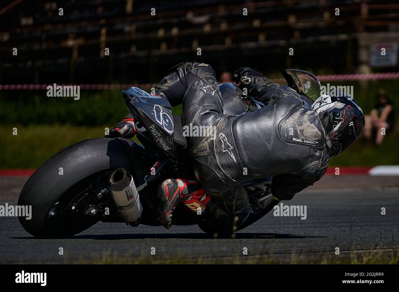 Riga, Latvia, 12-06-2021 Motorcycle rider takes corner. View from back ...