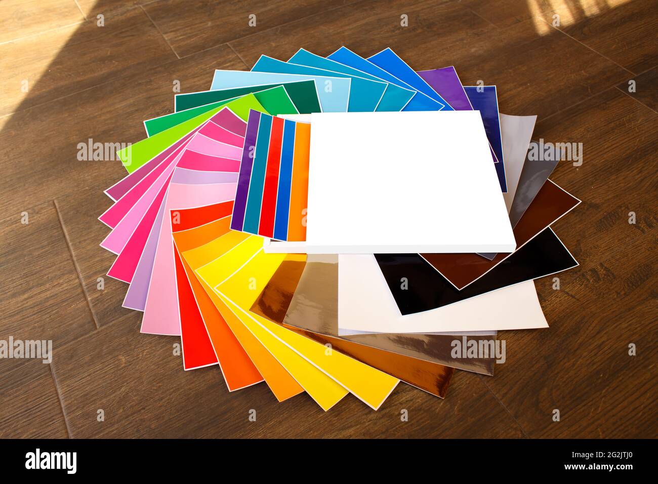 Twisted pile of colorful 12x12 sheets of adhesive paper isolated over ...