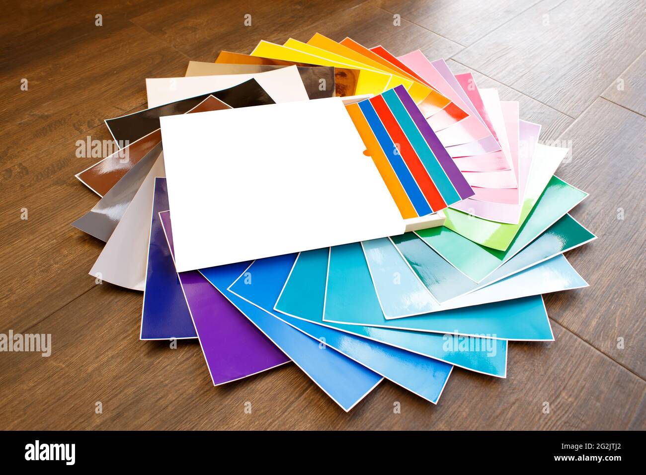 Twisted pile of colorful 12x12 sheets of adhesive paper isolated over ...