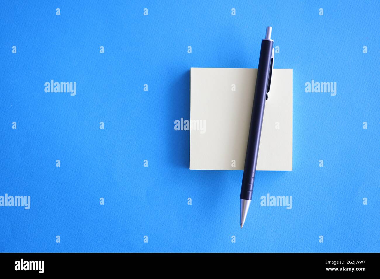 Ballpoint pen and paper stickers lying on blue background closeup Stock ...