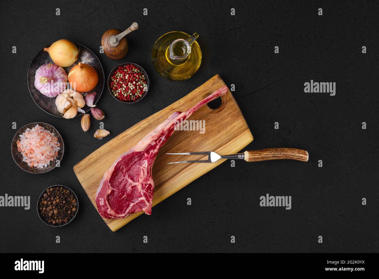 Overhead view of raw beef cowboy steak with spice and seasoning ready ...