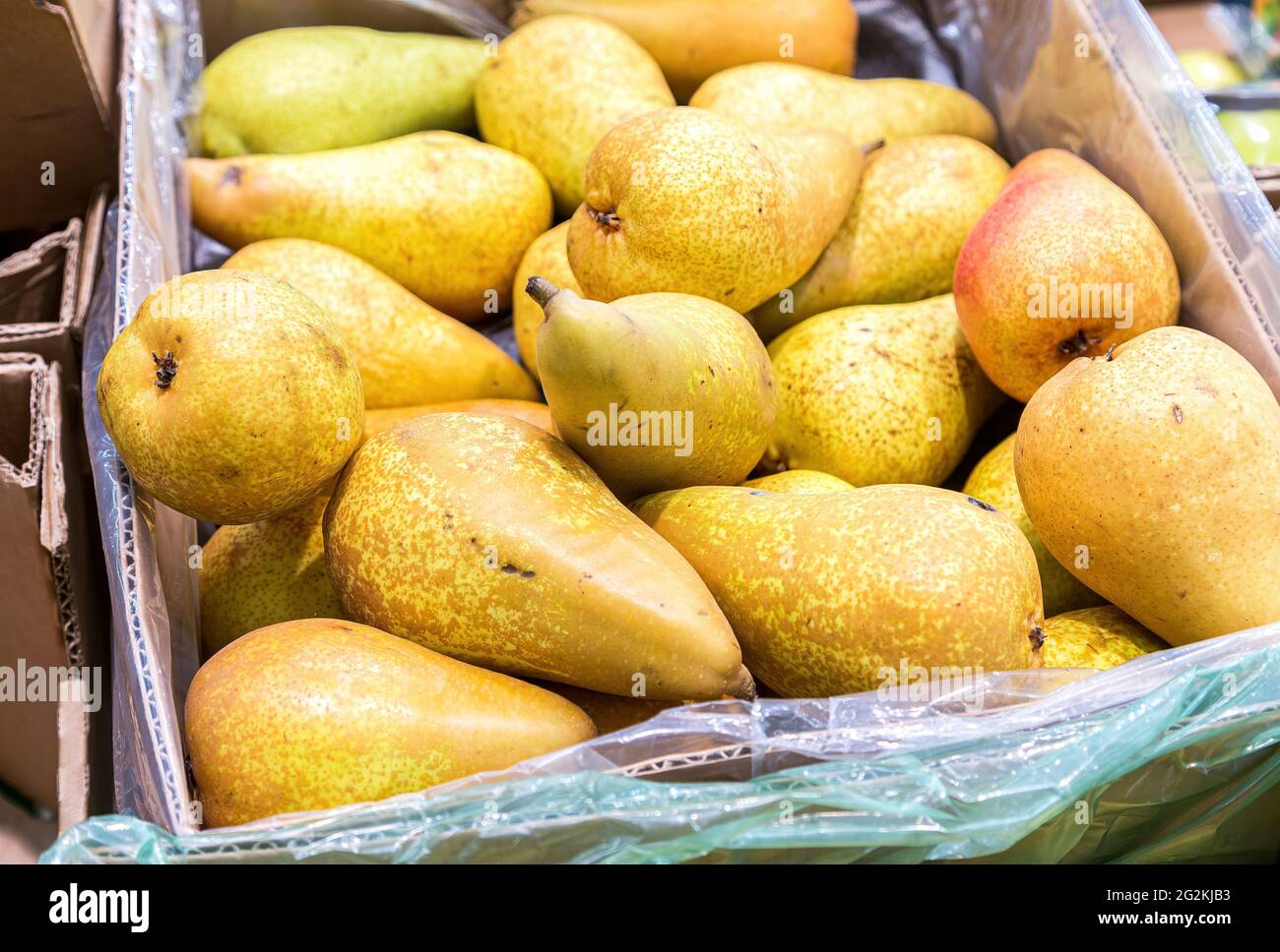 Fresh pears of new harvest in the cardboard box at the grocery store ...