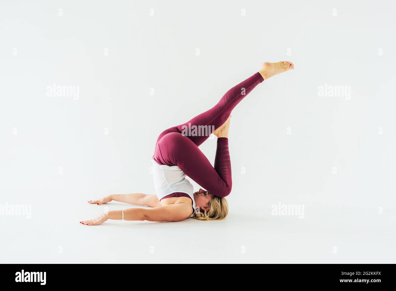 Woman gymnast in a stretching pose on a white background Stock Photo ...