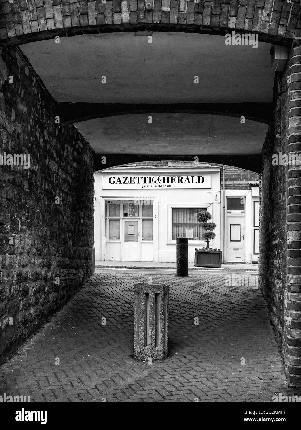 A covered brick walkway leads to a local newspaper office on the ...