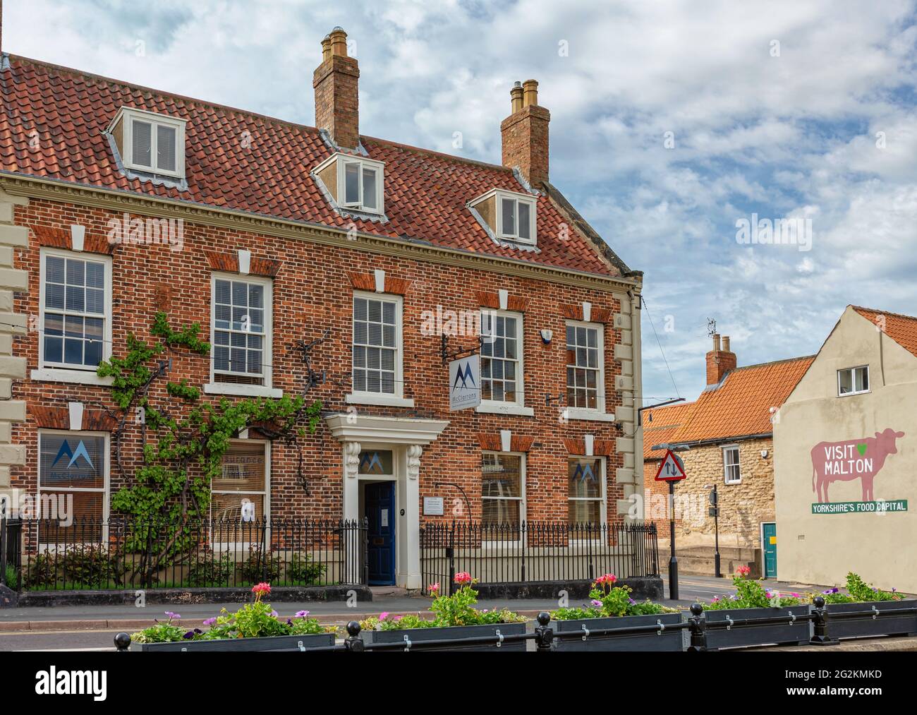 A brick 18th Century style building with metal railings in front. There ...