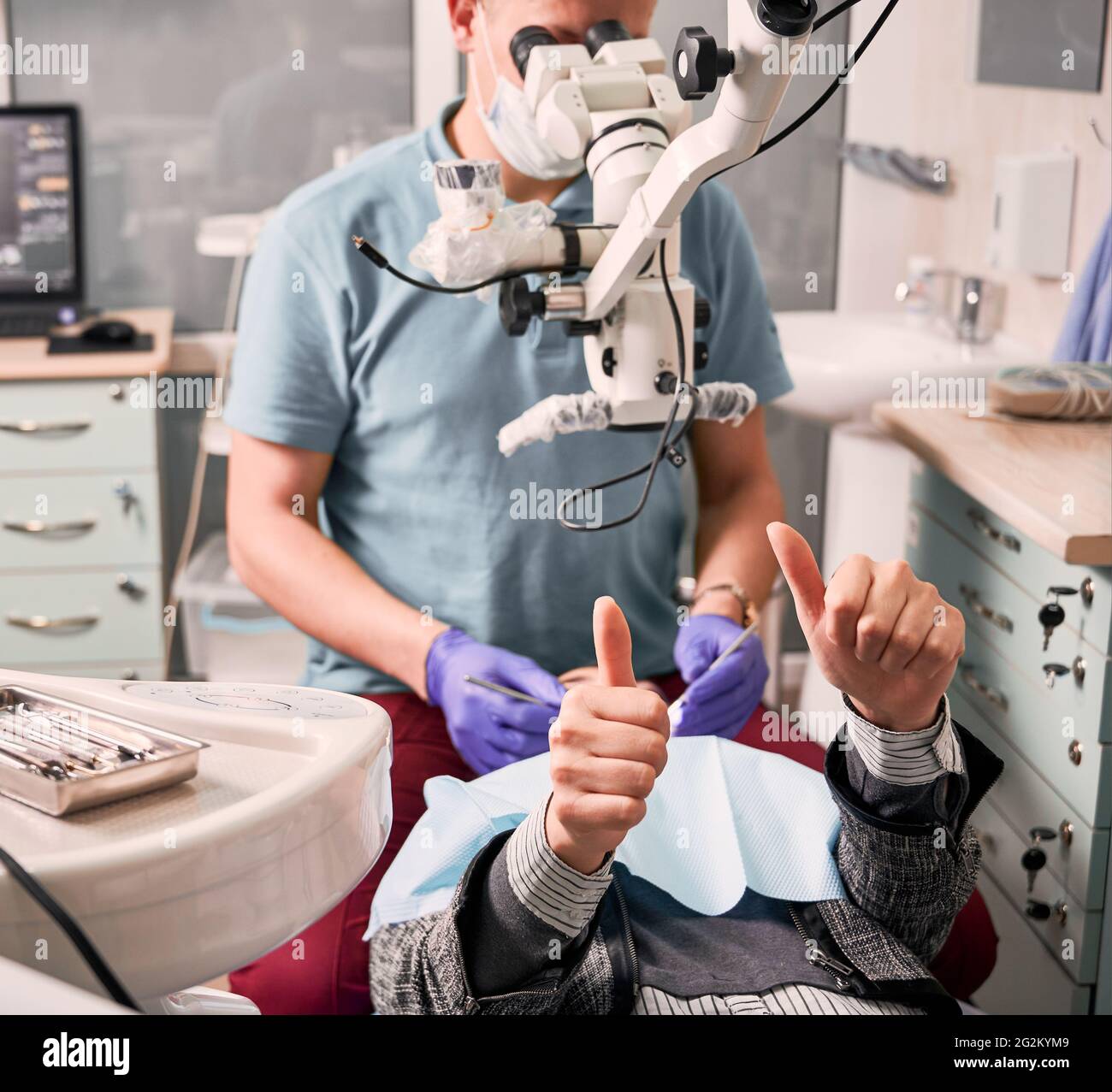 Close up of young woman showing approval gesture while lying in dental ...