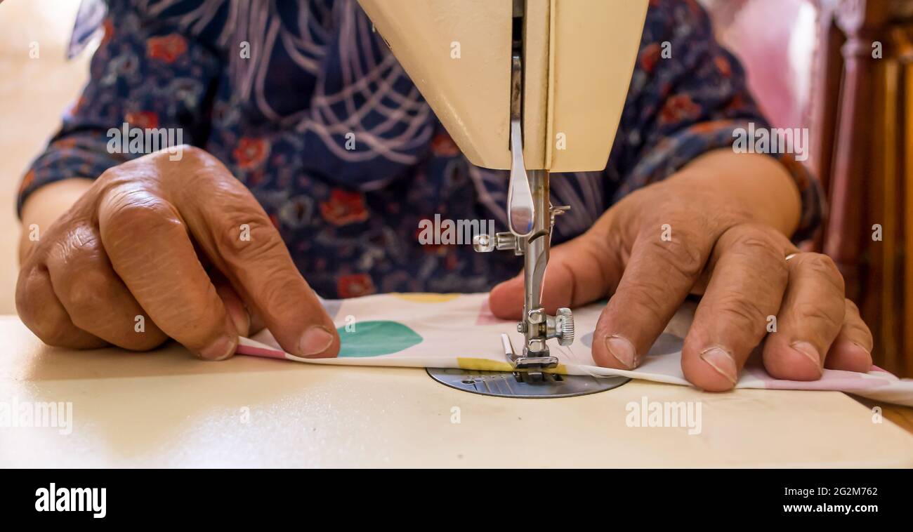 Close up of Old woman hand's using sewing machine, handmade concept ...