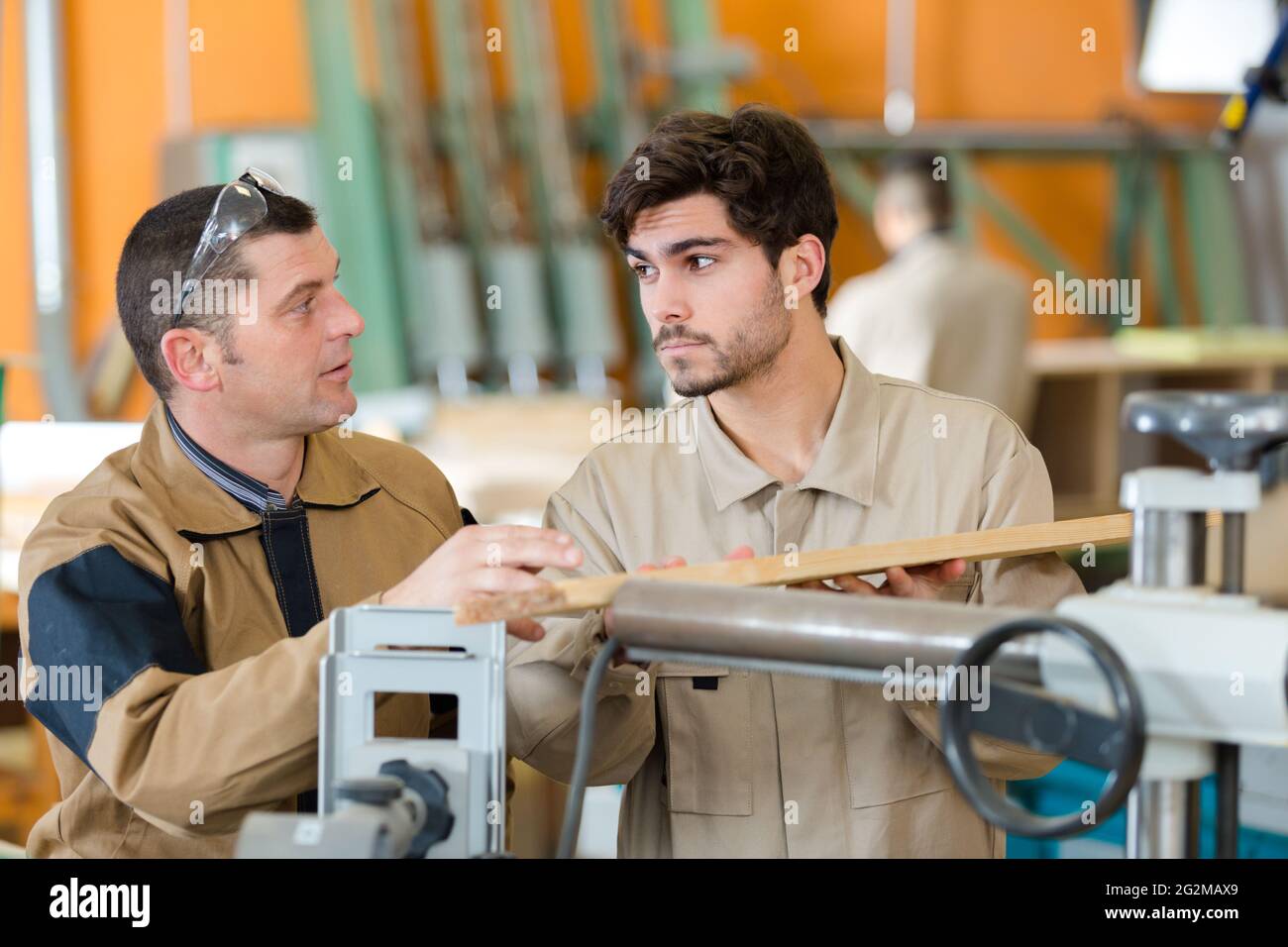 carpenter training apprentice to use plane Stock Photo - Alamy