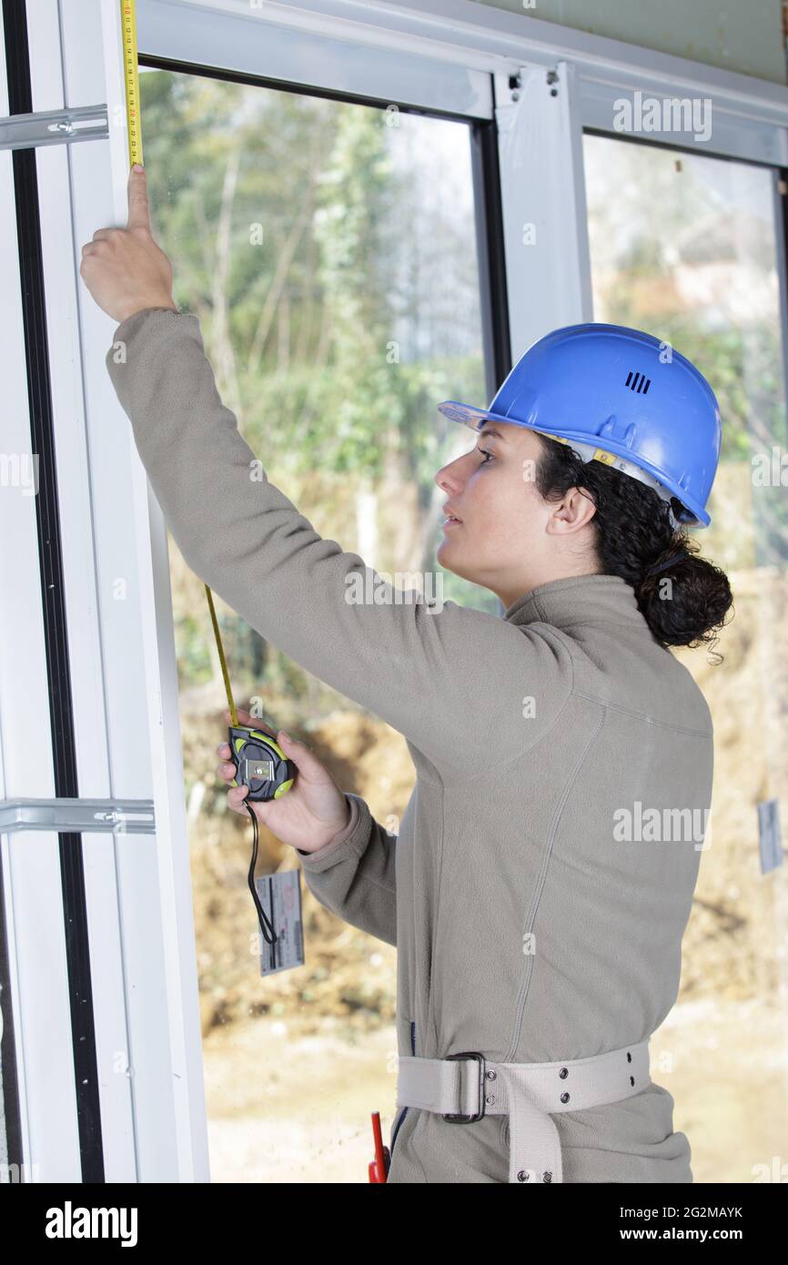 beautiful young woman measuring a window Stock Photo - Alamy