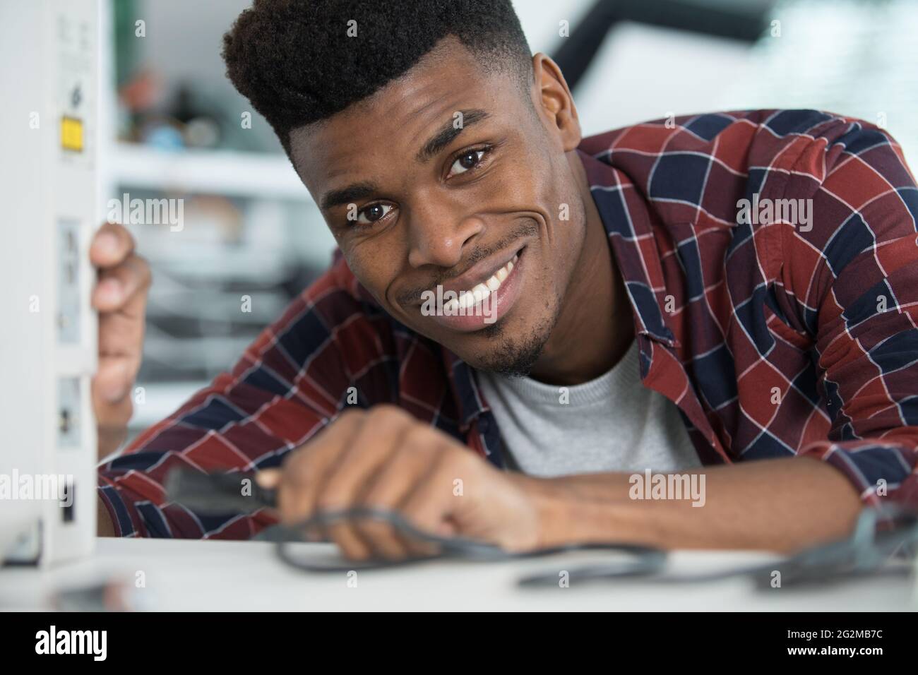 man inserting power lead into computer Stock Photo - Alamy