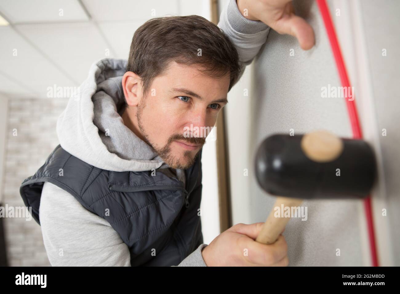 electrician tapping on wire for cladding Stock Photo - Alamy