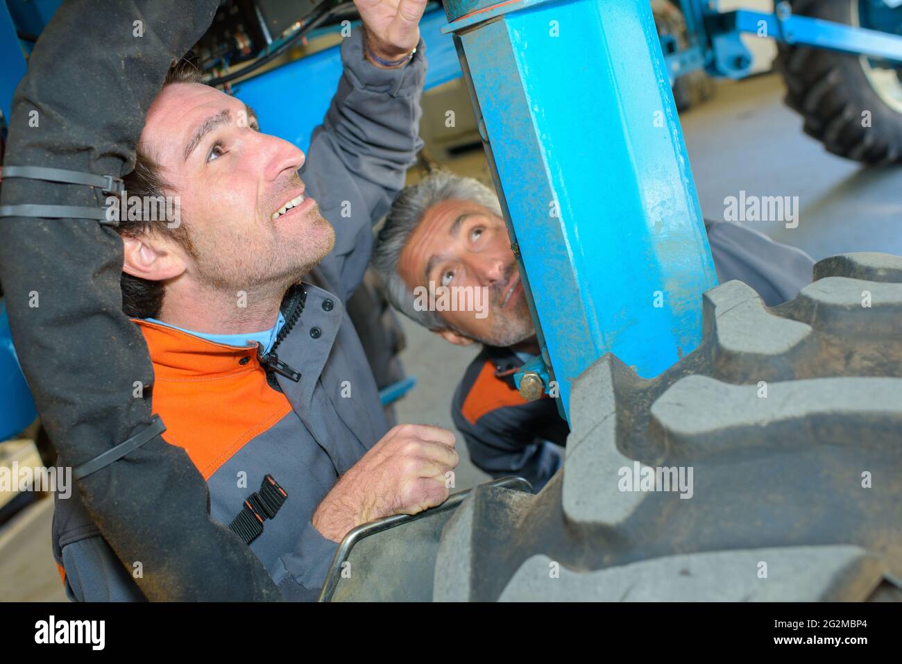 team of workers checking defect of the tractor Stock Photo - Alamy