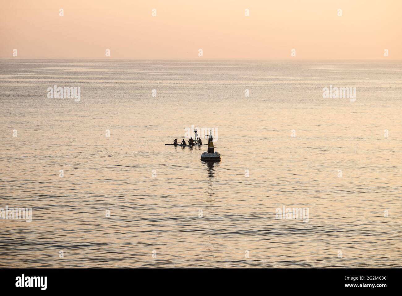 People swimming in the sea during the sunrise Stock Photo - Alamy