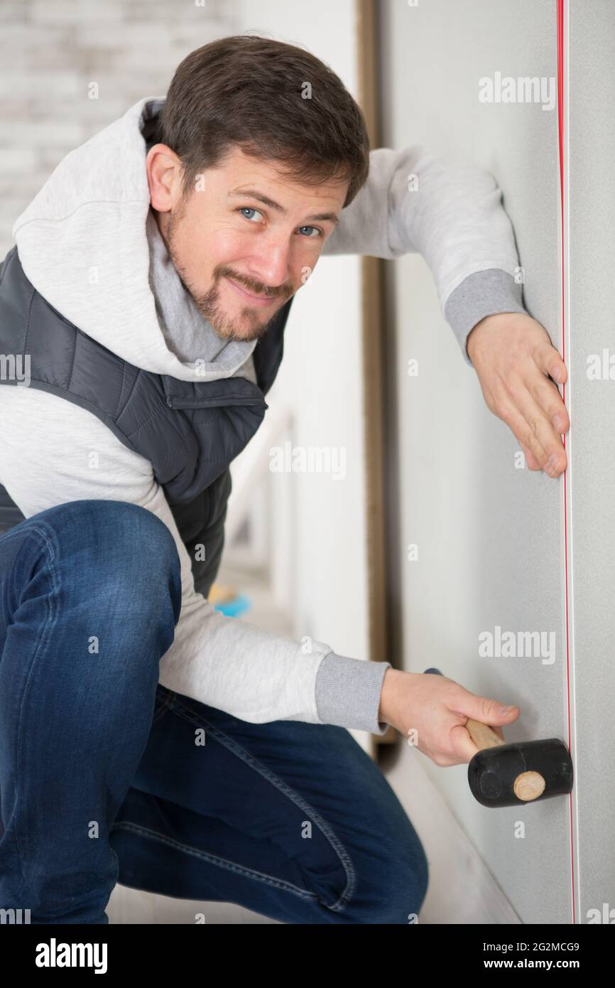 happy maintenance man is fixing a wall Stock Photo - Alamy