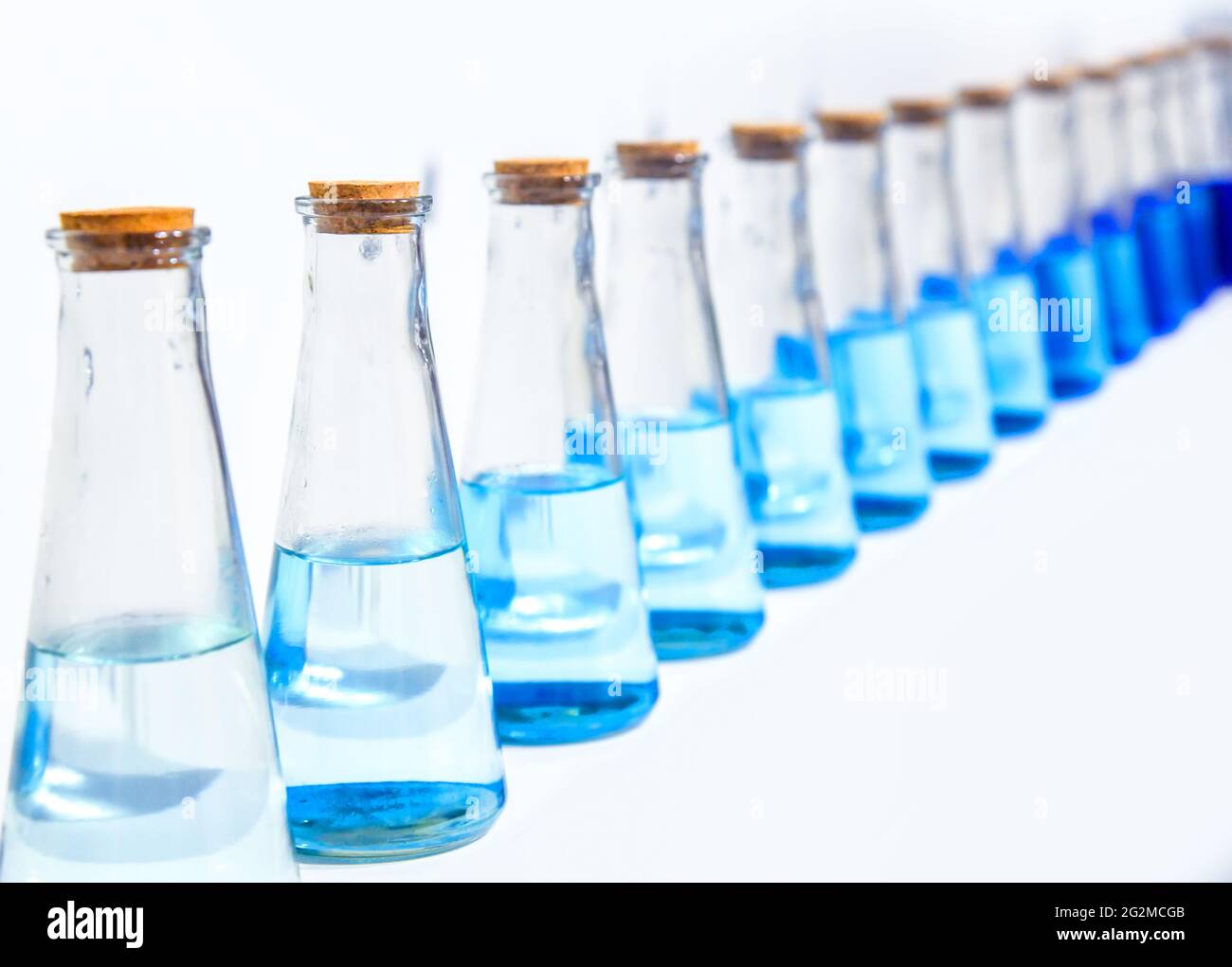 A glass bottle with blue liquid Stock Photo - Alamy