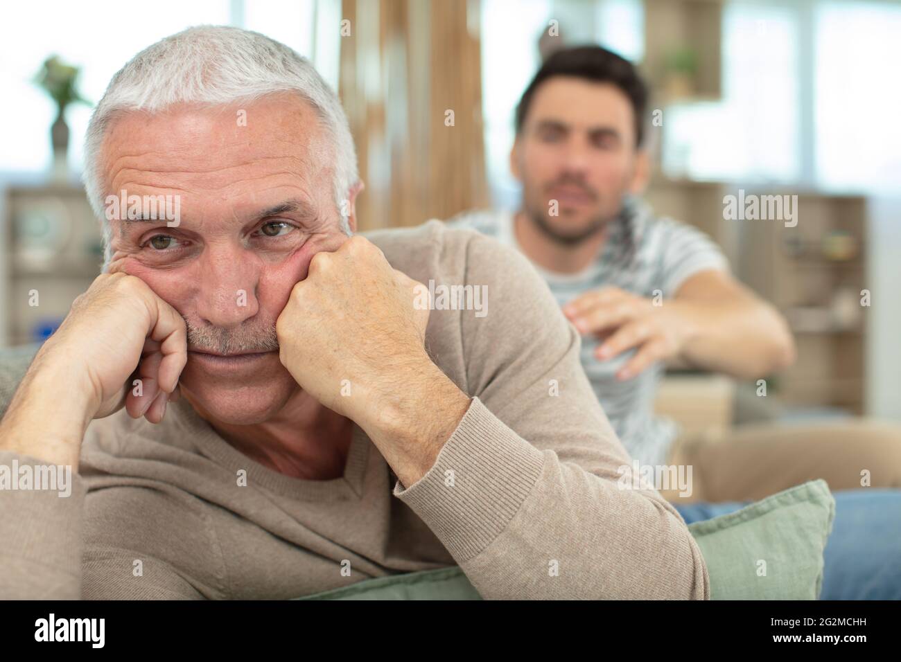 young compassionate man trying to talk to dad Stock Photo - Alamy