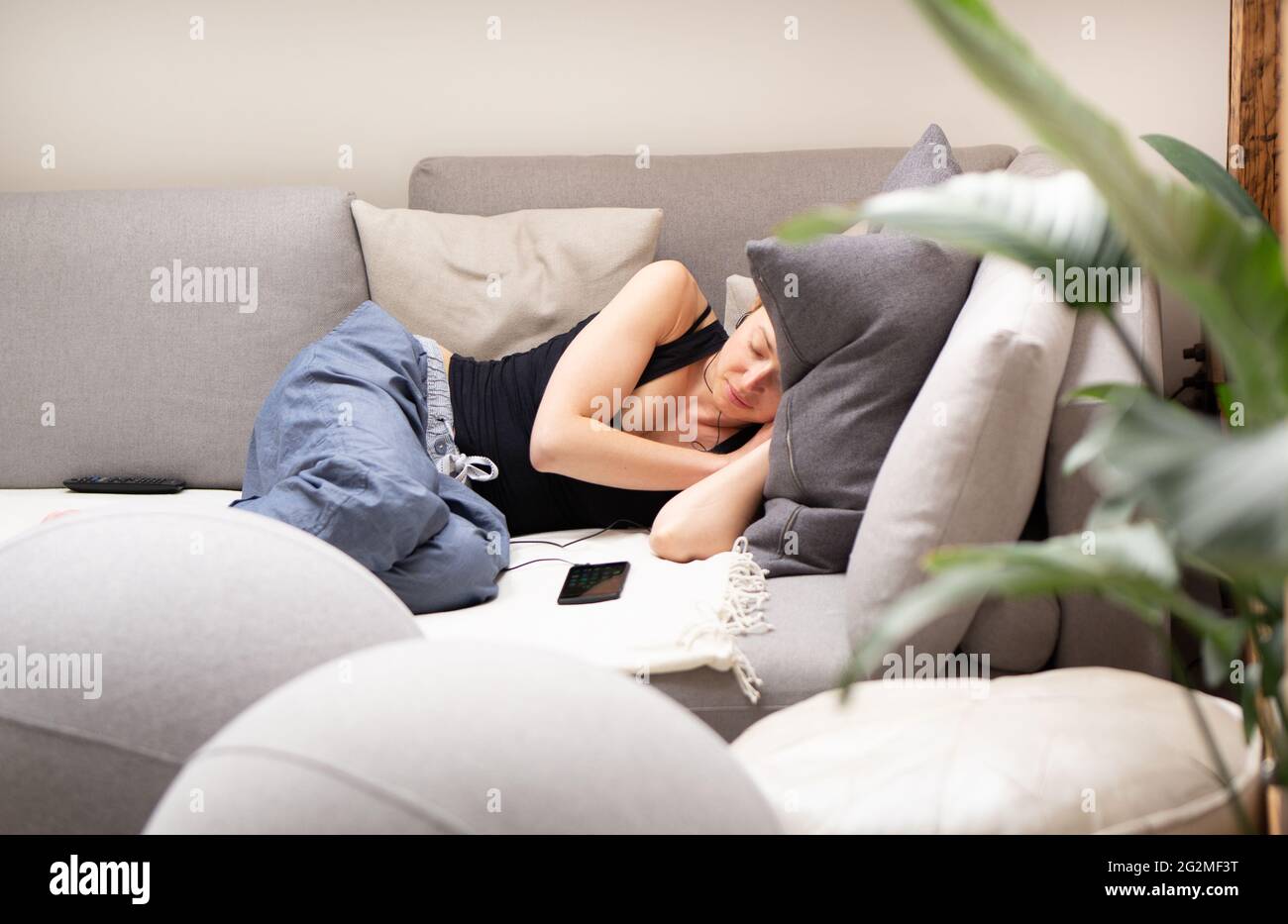 Tired girl lying on sofa hi-res stock photography and images - Alamy