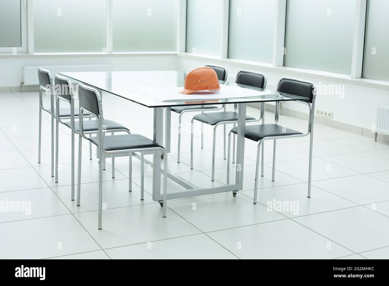 Construction hard hat blueprints on glass table in office space Stock ...
