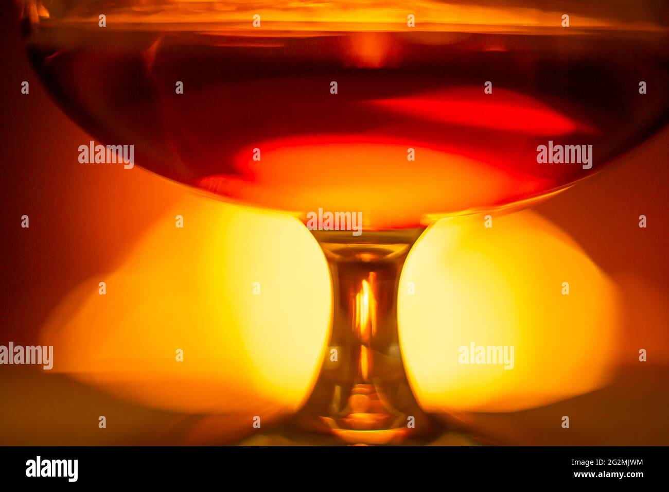 A glass of cognac near the burning fireplace. Concept winter evening ...