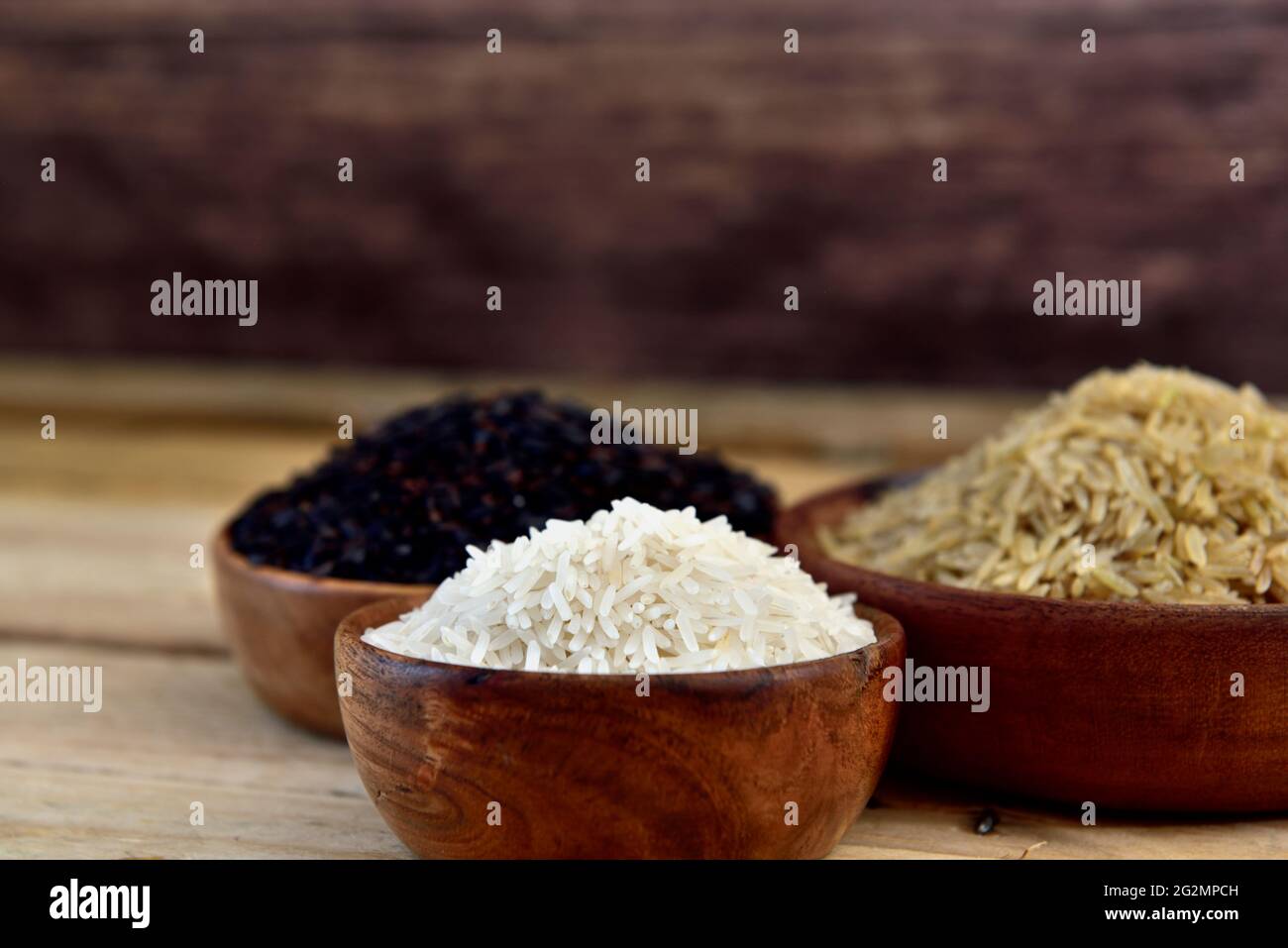 organic white brown and black rice in a wooden bowls Stock Photo - Alamy