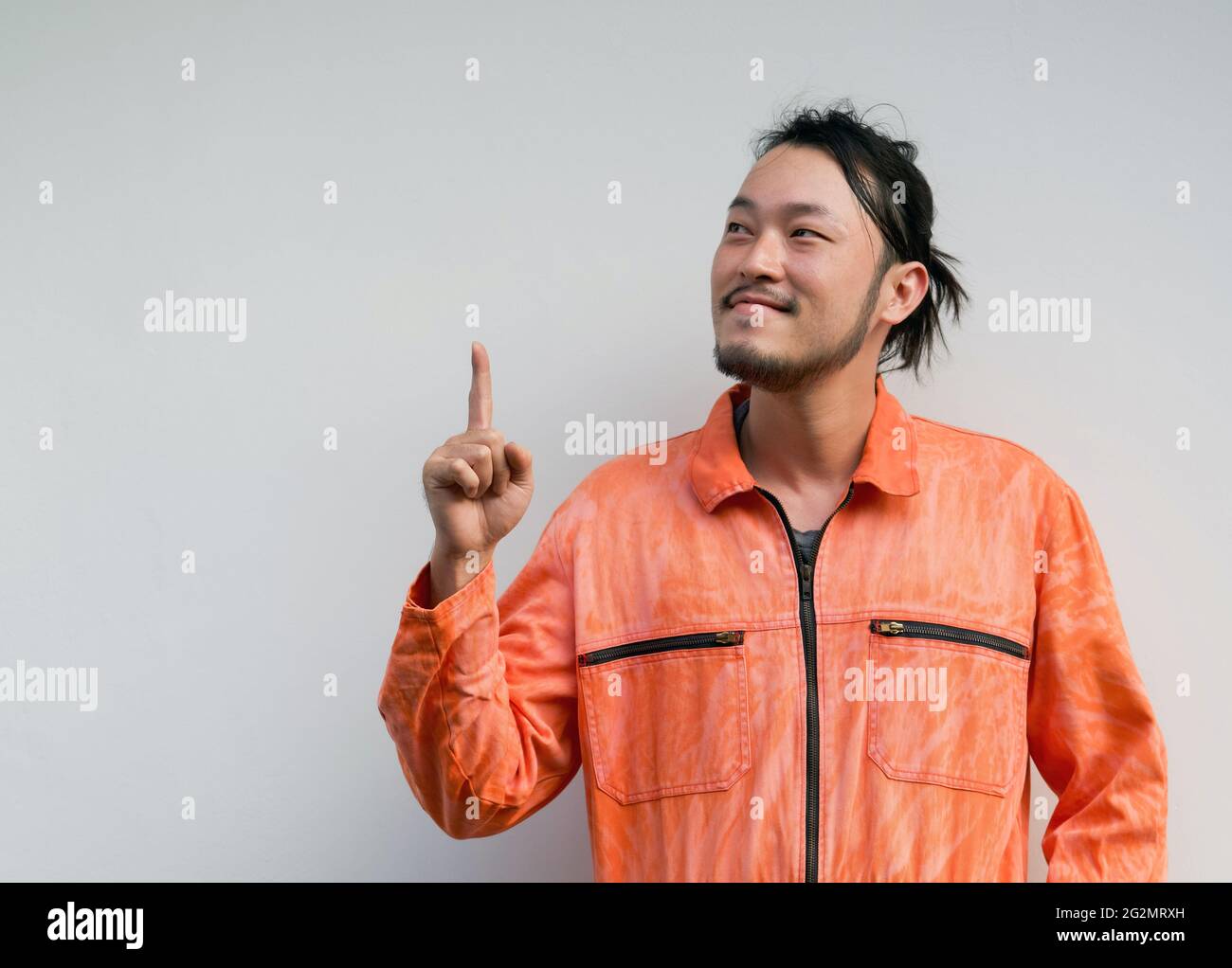 The chief mechanic in an orange uniform pointing one finger in upward ...