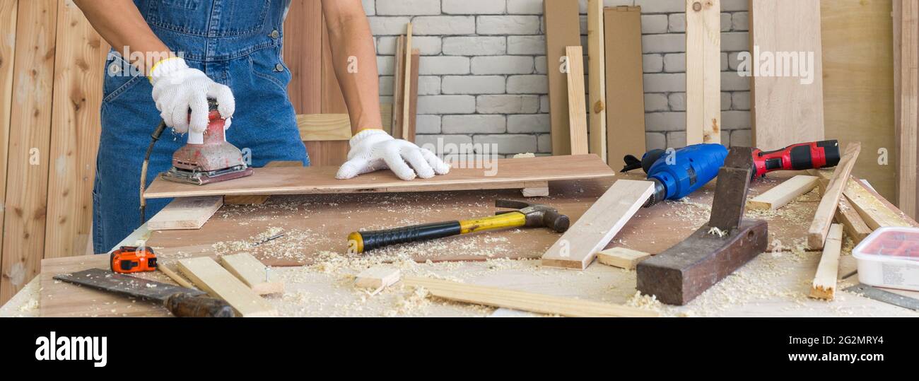 Carpentry use a sander machine to smooth plywood surfaces by abrasion ...