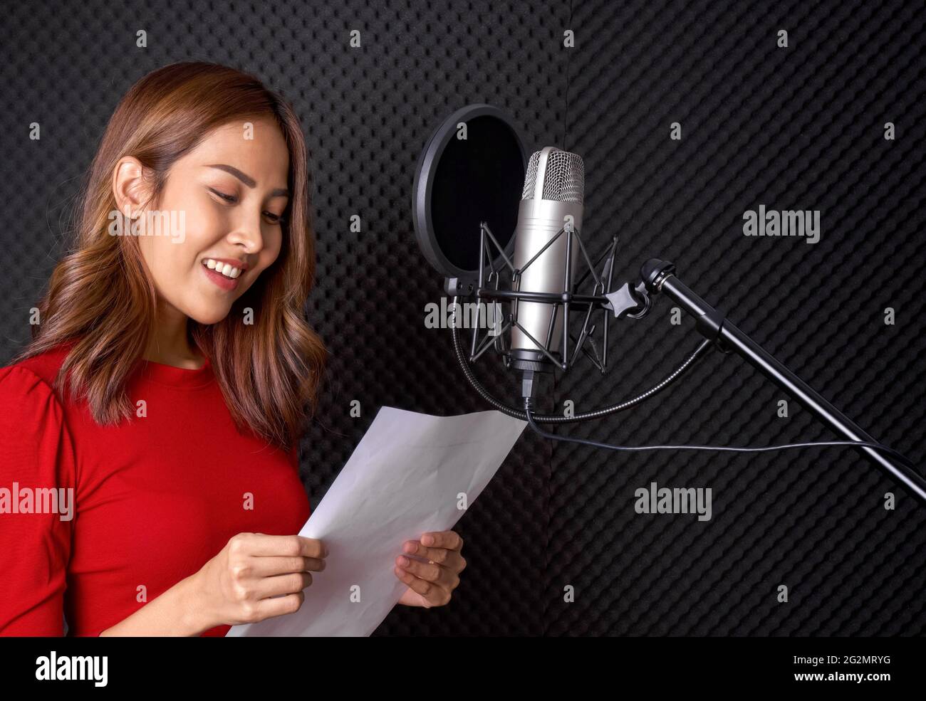 Young asian woman in red long sleeve t-shirt sing while holding lyrics ...