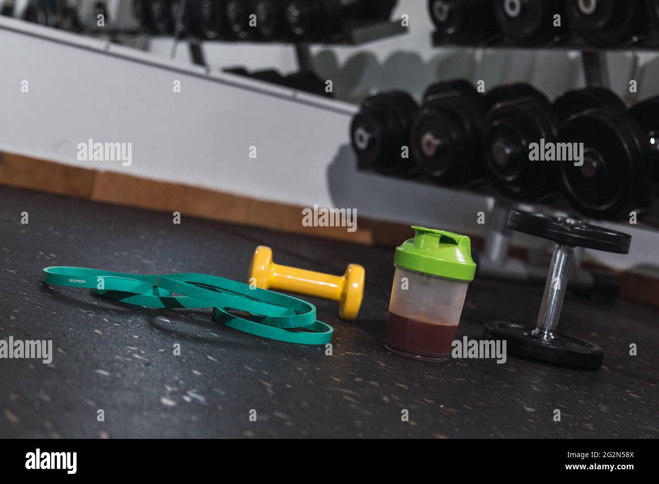 Protein shake and dumbbells at the gym. Fitness nutrition drink and ...