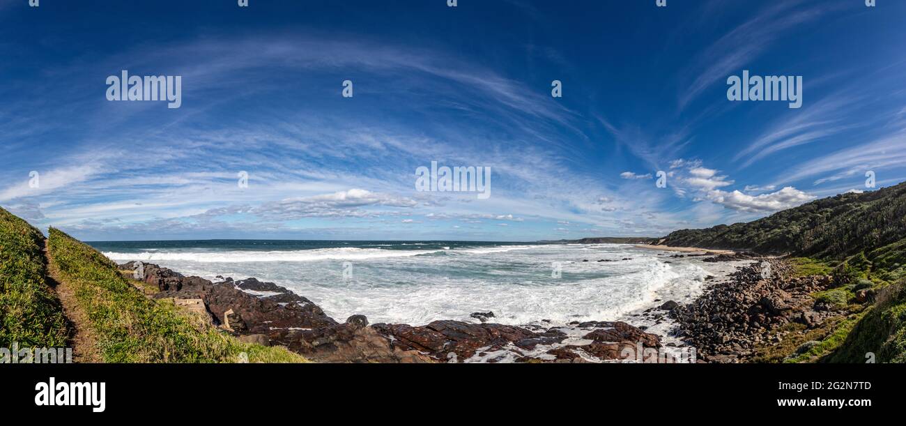 Panoramic paradise: Sweeping coastal vista with azure skies, wispy ...