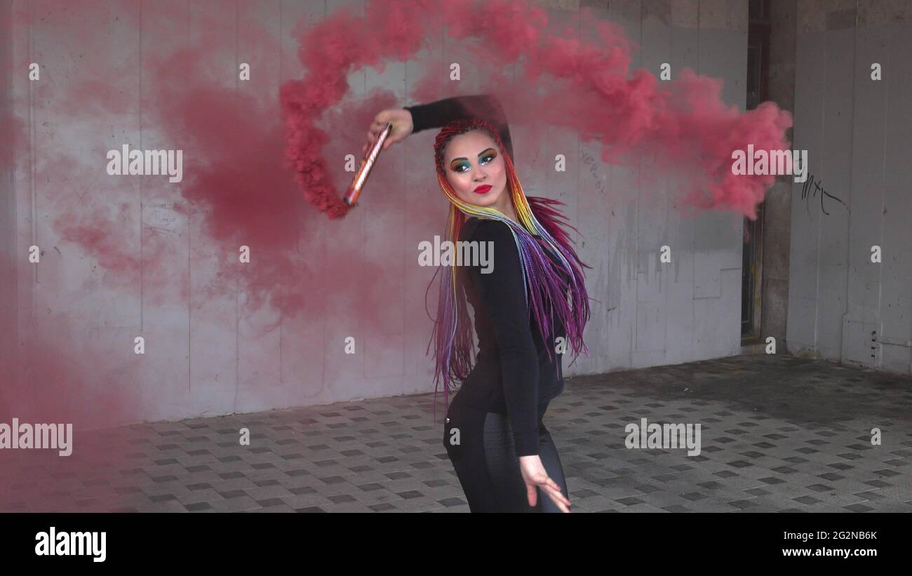 Attractive girl with multicolored braids and makeup in an black dress ...