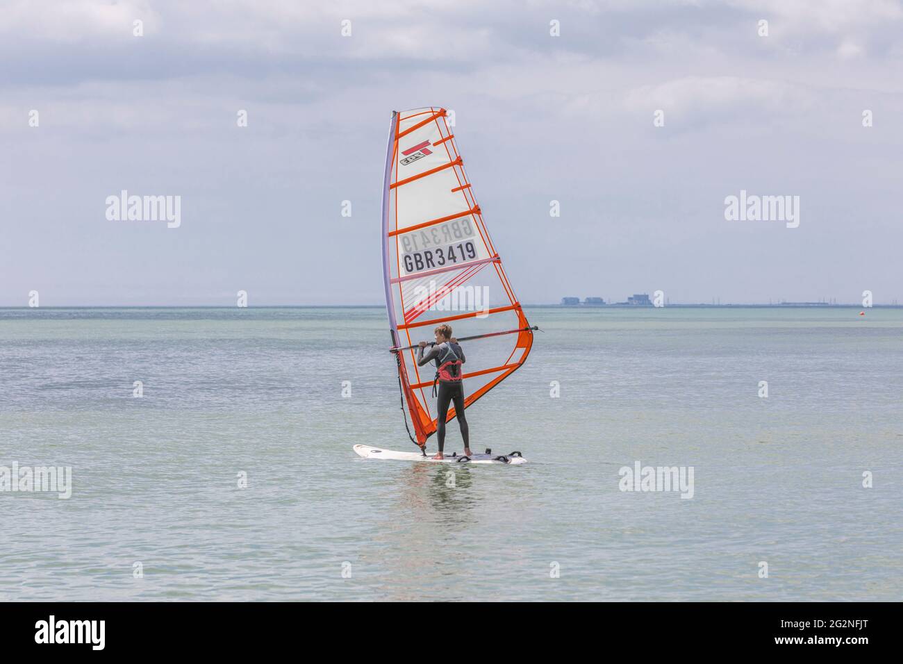 A wind surfer in Hythe with Dungeness Nuclear Power Station in the ...