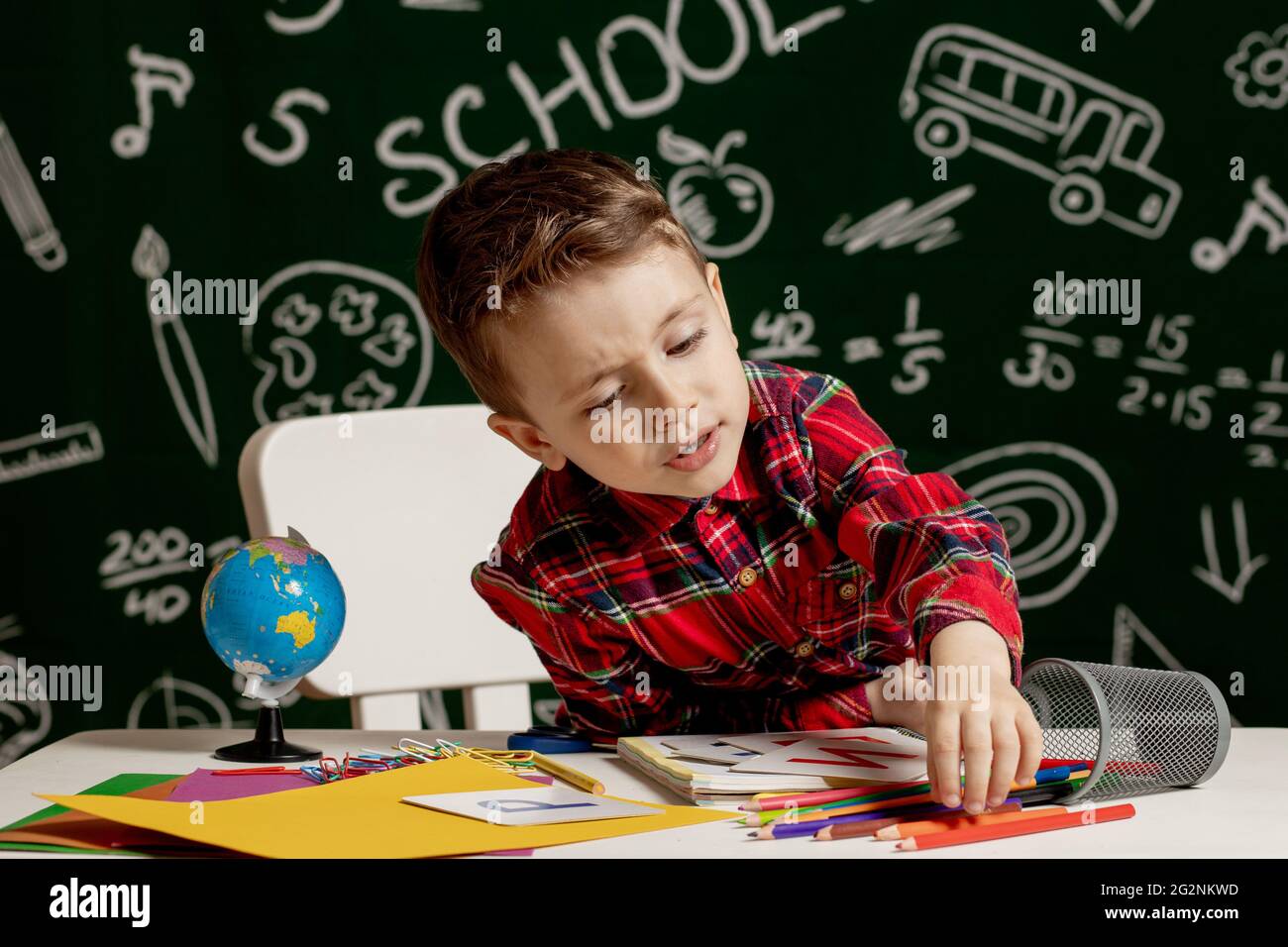 Preschooler boy making school homework. School boy with happy face ...