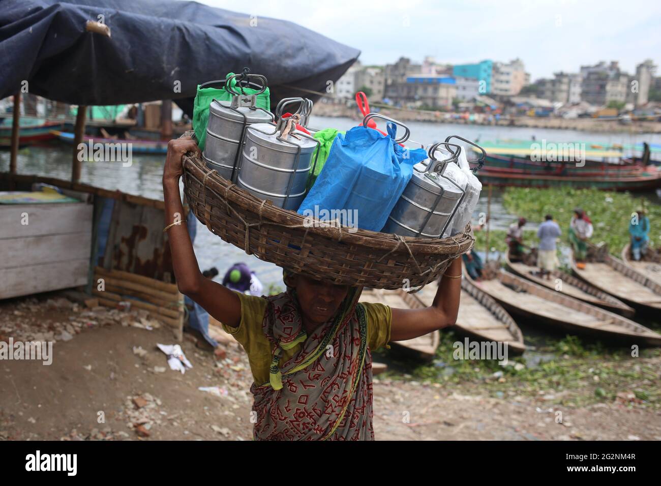 Dhaka, Bangladesh. 12th June, 2021. A women is carrying a basket full ...