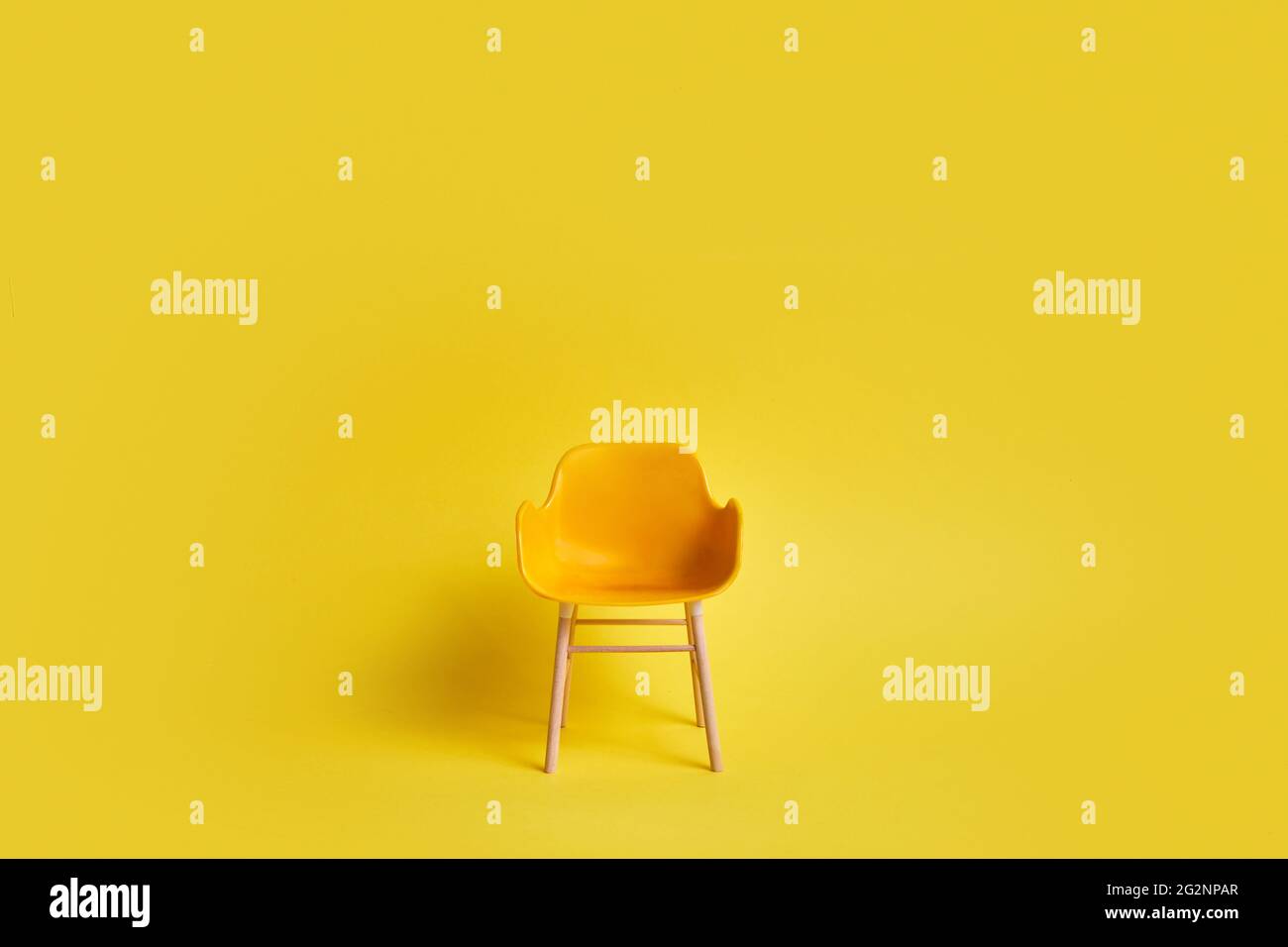 Yellow chair on the background of a yellow wall. Simple interior Stock ...