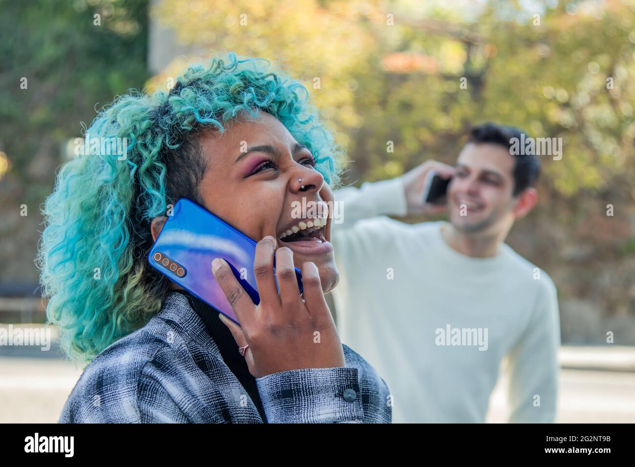 young people talking on the mobile phone in the street Stock Photo - Alamy