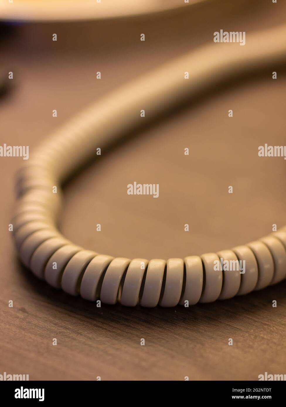 closeup of single curved spiral cable white wire. Phone line. Long ...