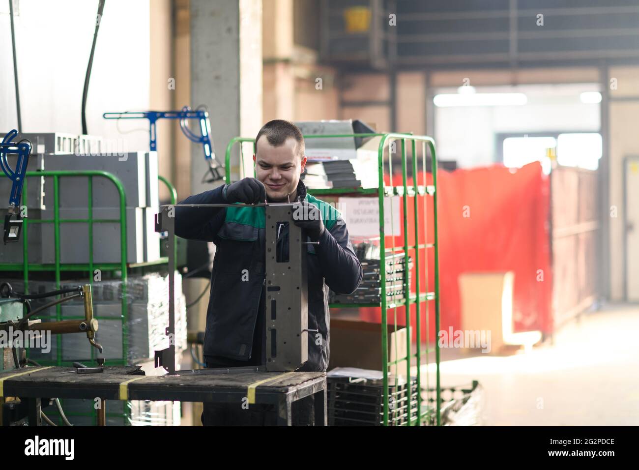 a uniformed worker working in a modern metal production and processing ...