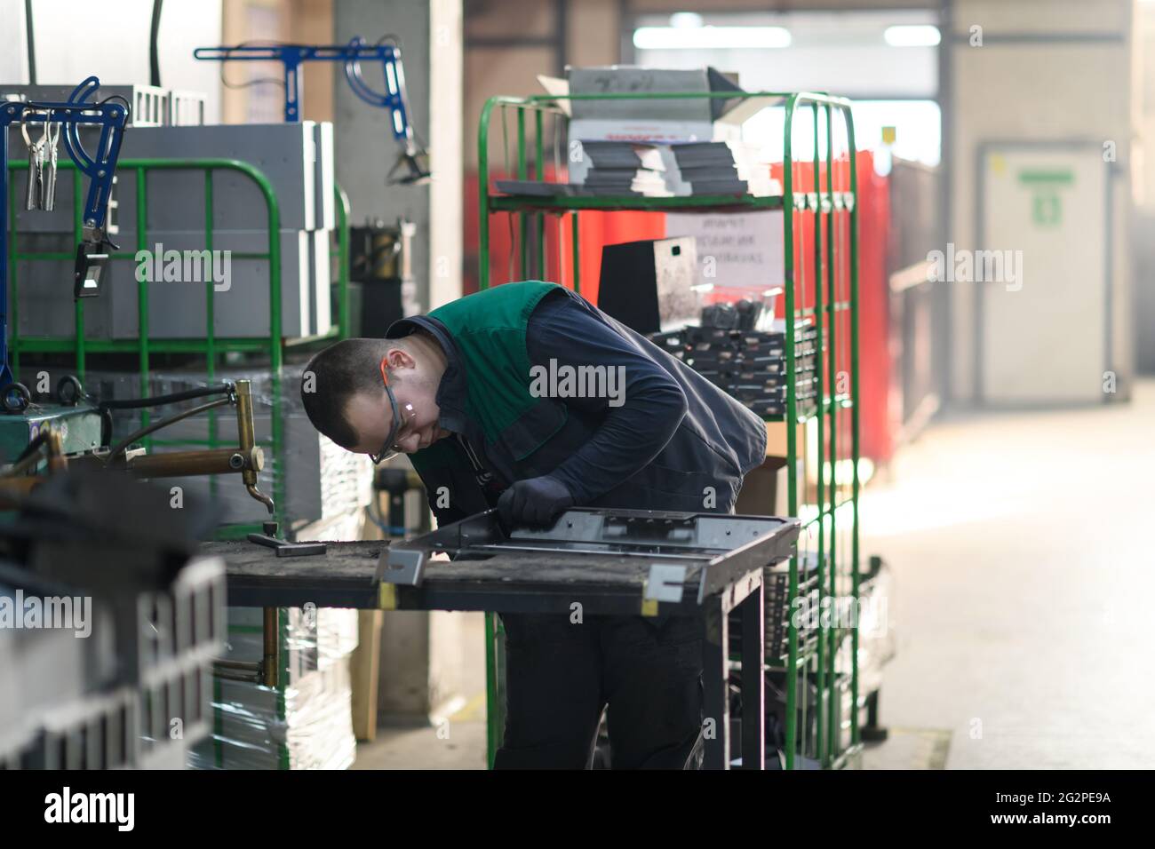 a uniformed worker working in a modern metal production and processing ...