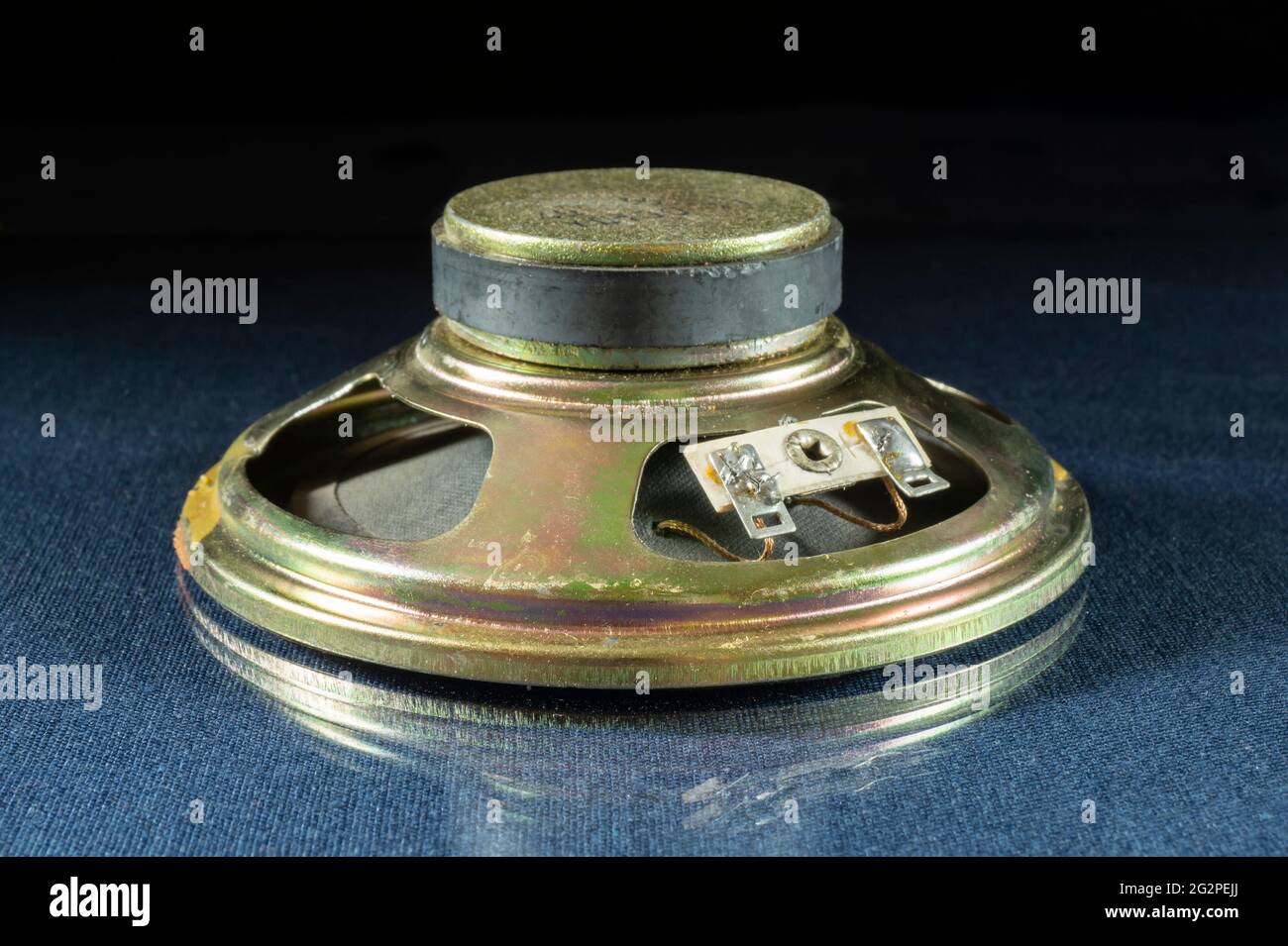 Electric speaker on the table with reflection. Spare parts on a black ...