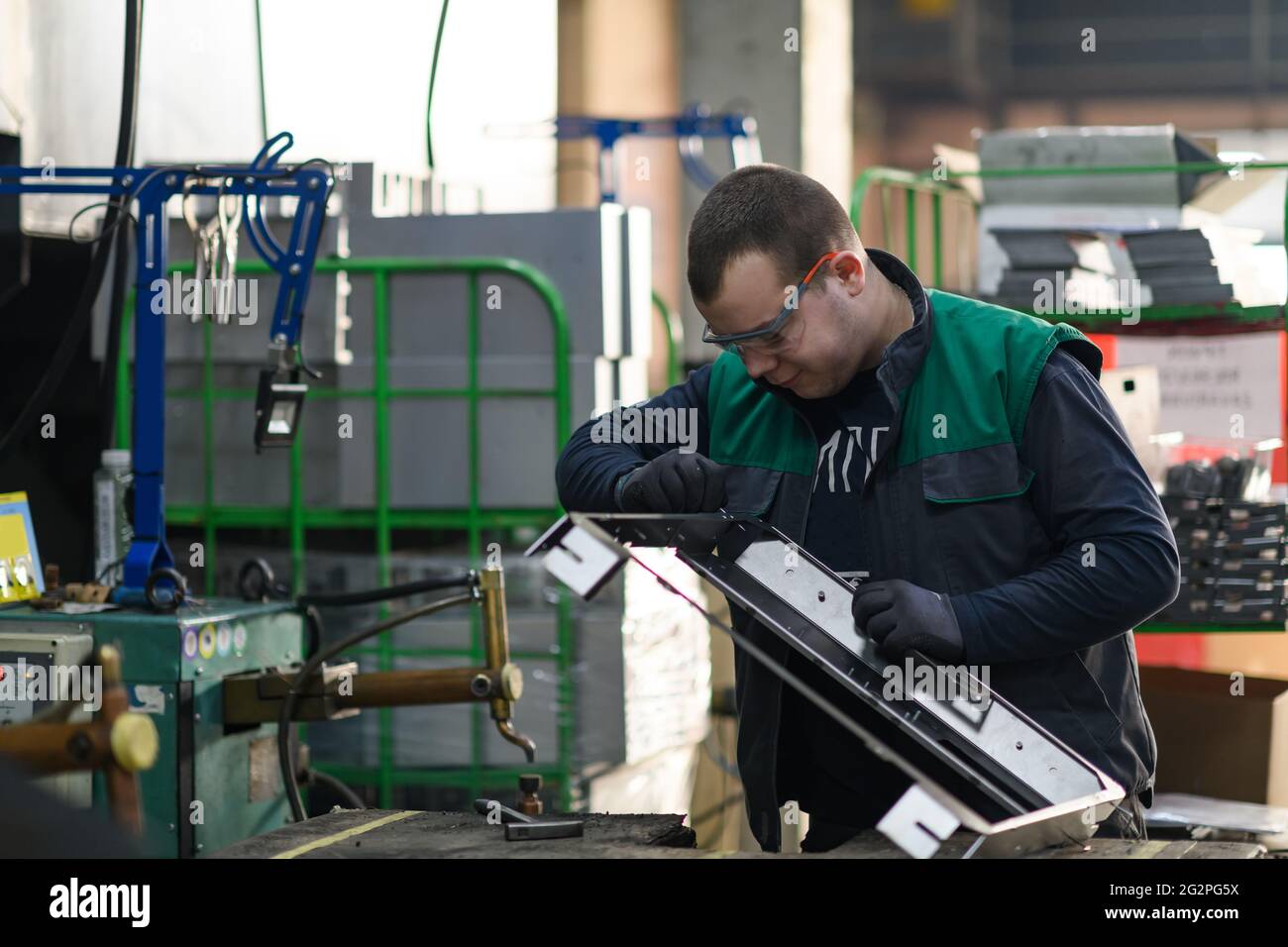 a uniformed worker working in a modern metal production and processing ...