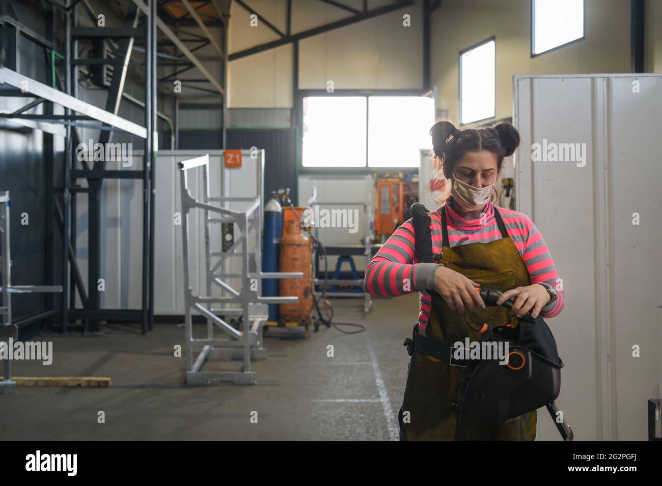 A female welder preparing for a working day in the metal processing ...