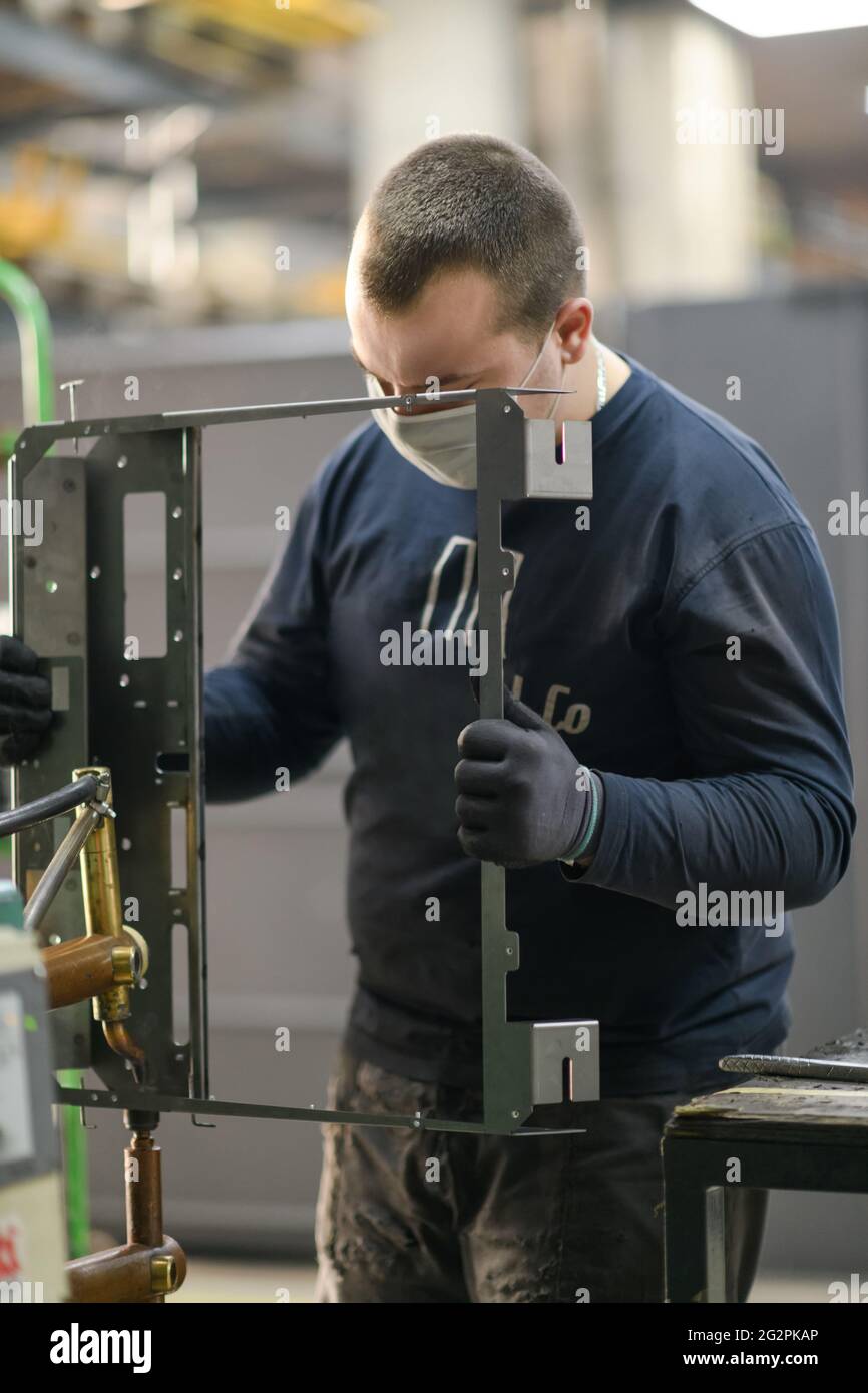 a uniformed worker working in a modern metal production and processing ...