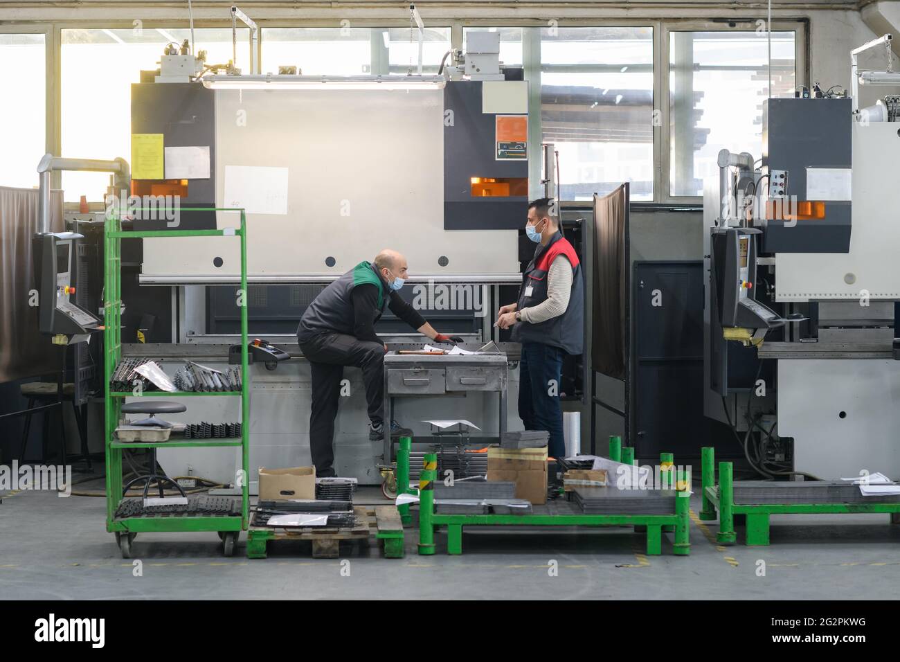 Cnc machine and workers with mask hi-res stock photography and images ...
