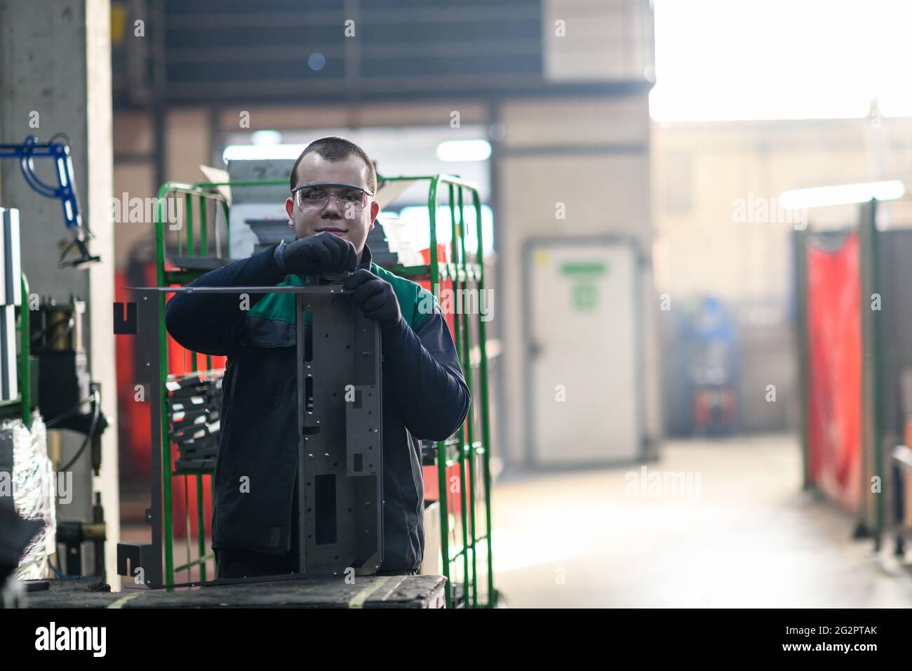 a uniformed worker working in a modern metal production and processing ...