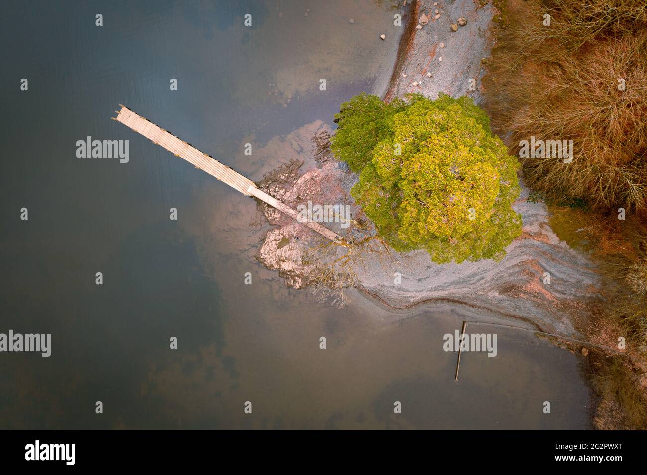 Aerial birds eye view of long wooden jetty on shoreline of island in ...