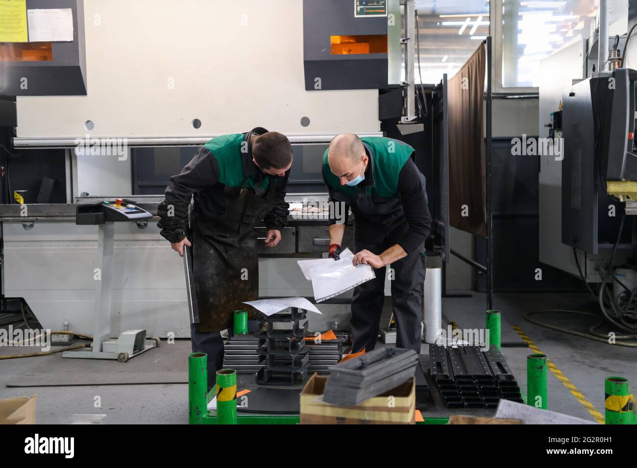 Cnc machine and workers with mask hi-res stock photography and images ...