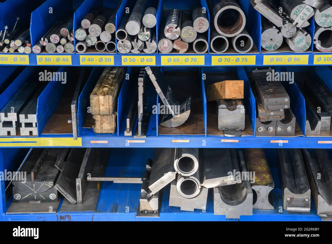 pipes, metal pieces and various metal parts for a CNC machine standing ...